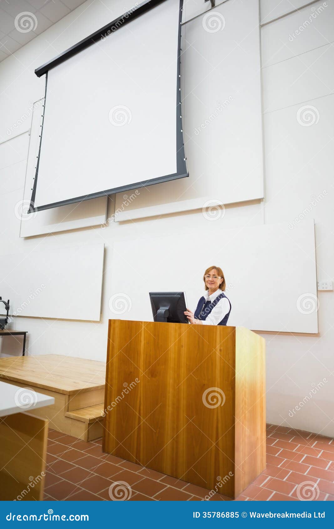 Teacher with Computer and Projection Screen in Lecture Hall Stock Image ...