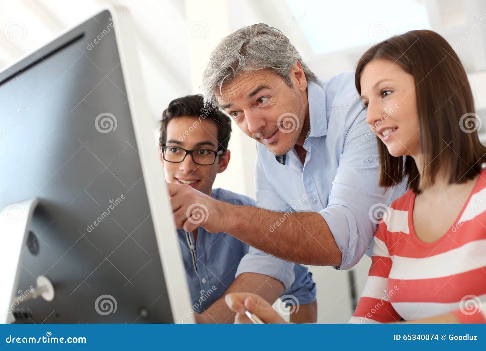 Teacher with Couple of Students in Front of Computer Stock Photo ...