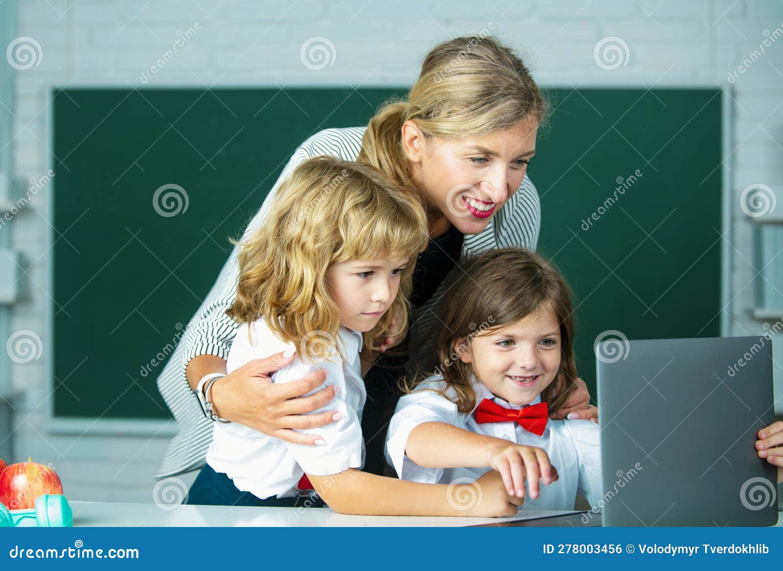 Teacher with Elementary School Pupils Using Laptop at Desk. Stock Photo ...