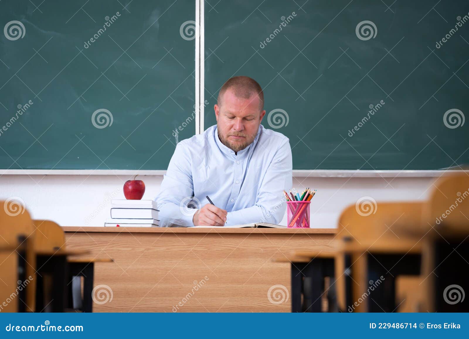 Teacher in empty classroom stock photo. Image of concept - 229486714