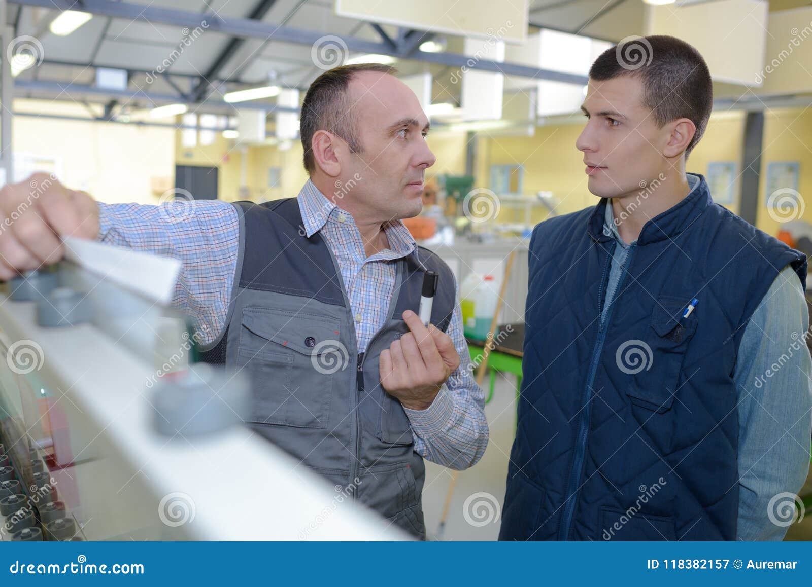 Teacher Encouraging Apprentice Using Machinery Stock Image - Image of ...