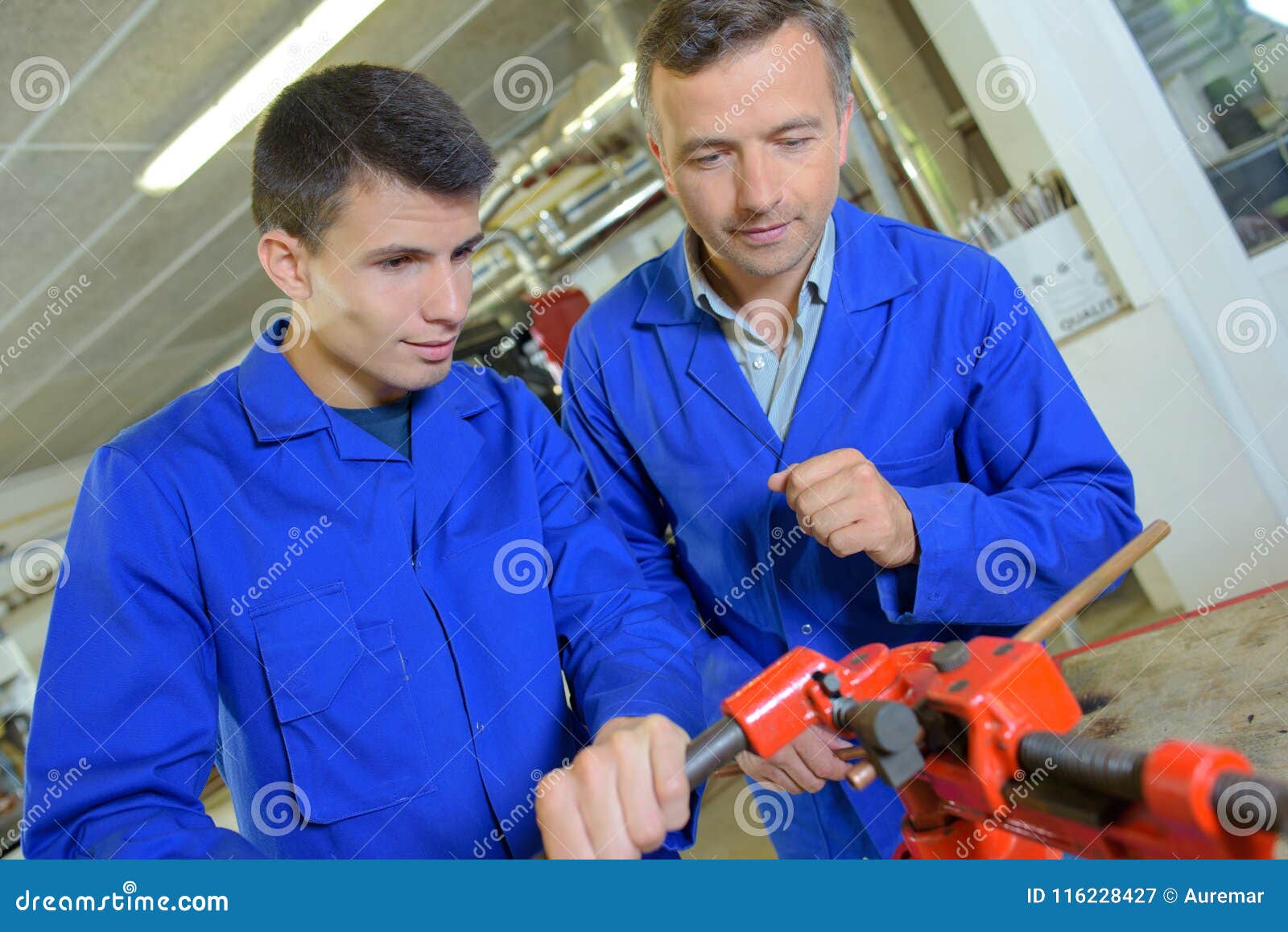 Teacher Encouraging Apprentice Using Machinery Stock Image - Image of ...