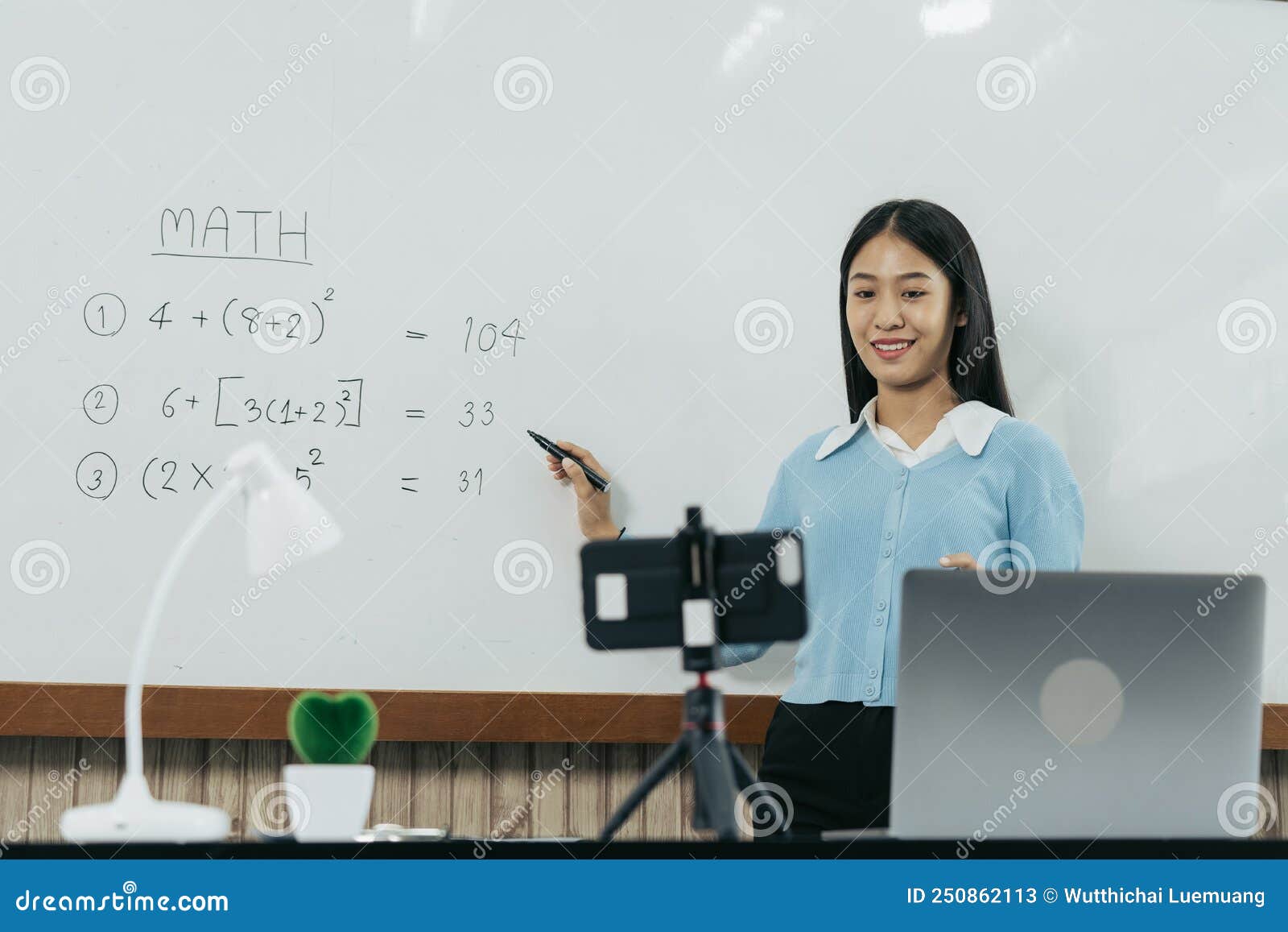 Teacher Explaining the Numbers on the Board while Video Calling with ...