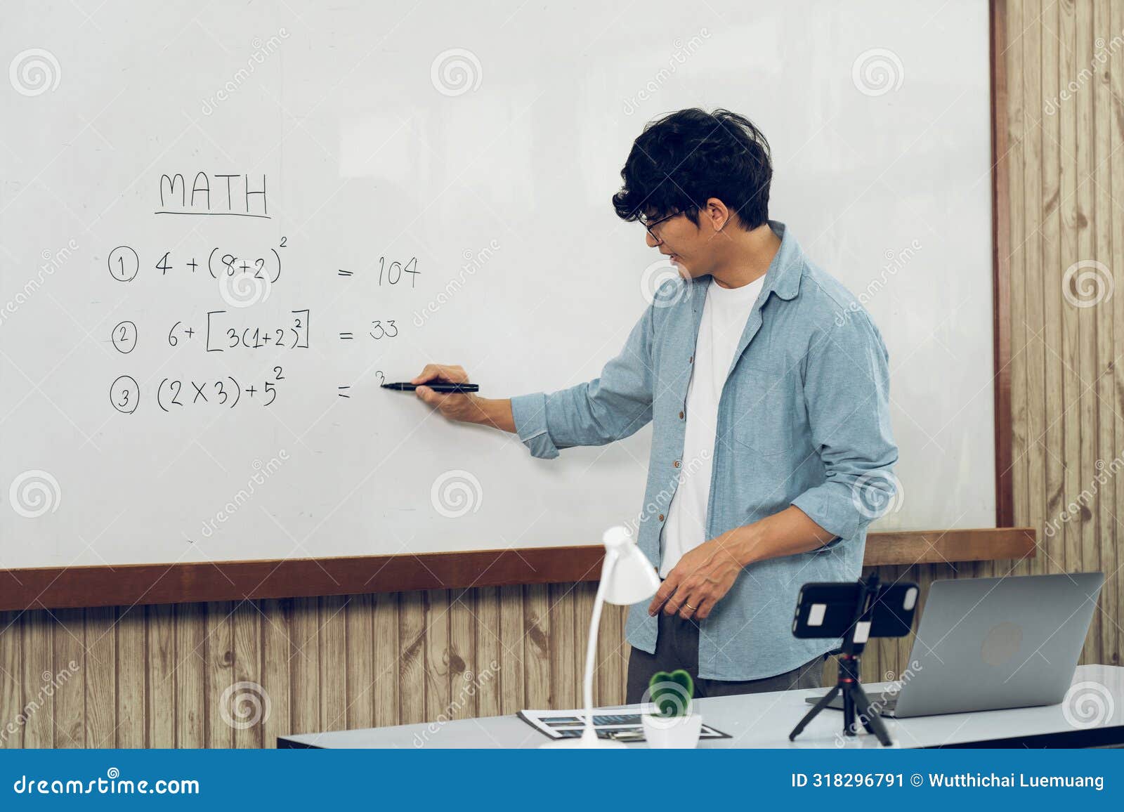 Teacher Explaining the Numbers on the Board while Video Calling with ...