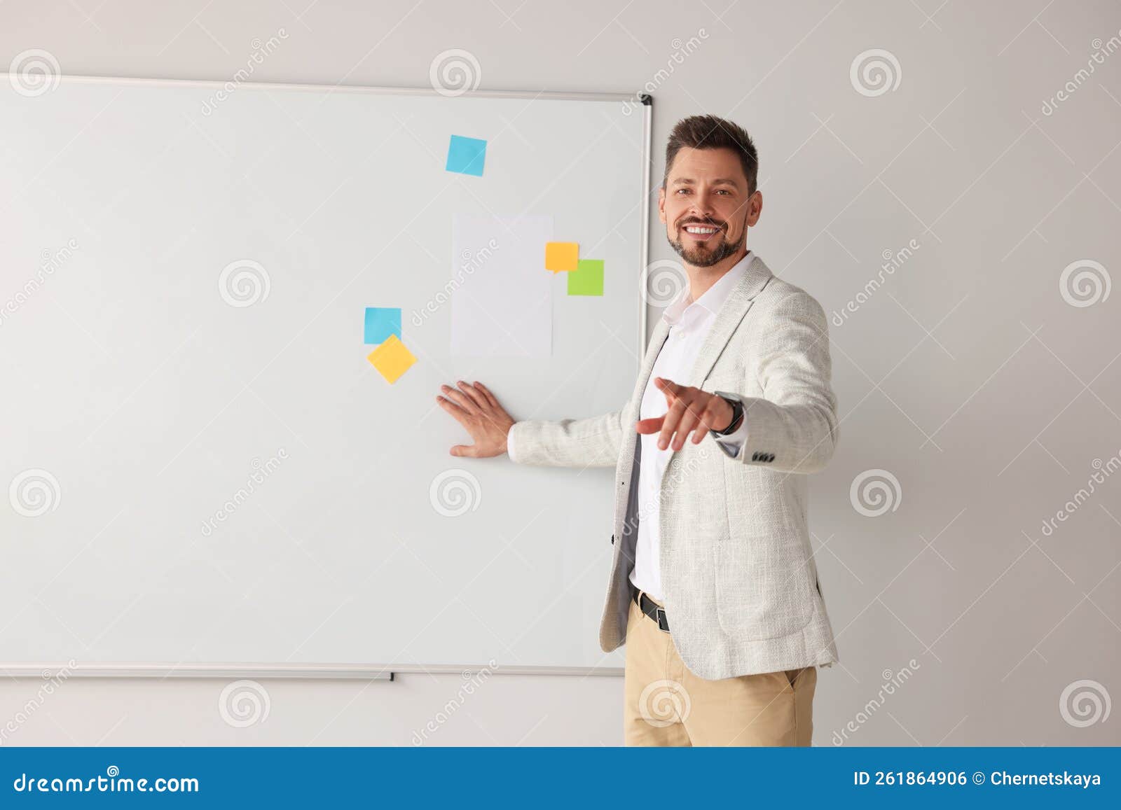 Happy Teacher Explaining Something at Whiteboard in Classroom. Space ...