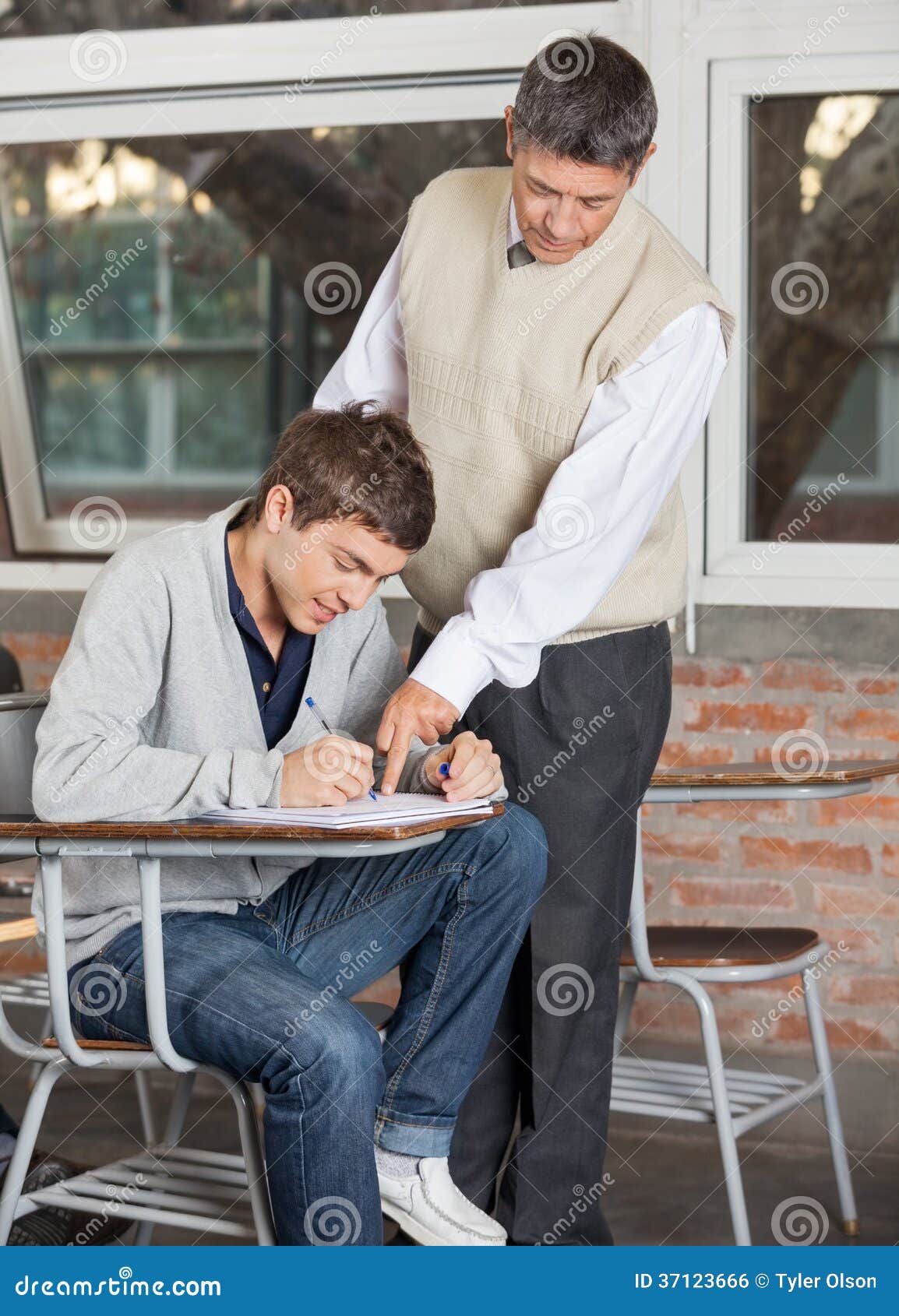 Teacher Explaining Test To Student in Classroom Stock Photo - Image of ...