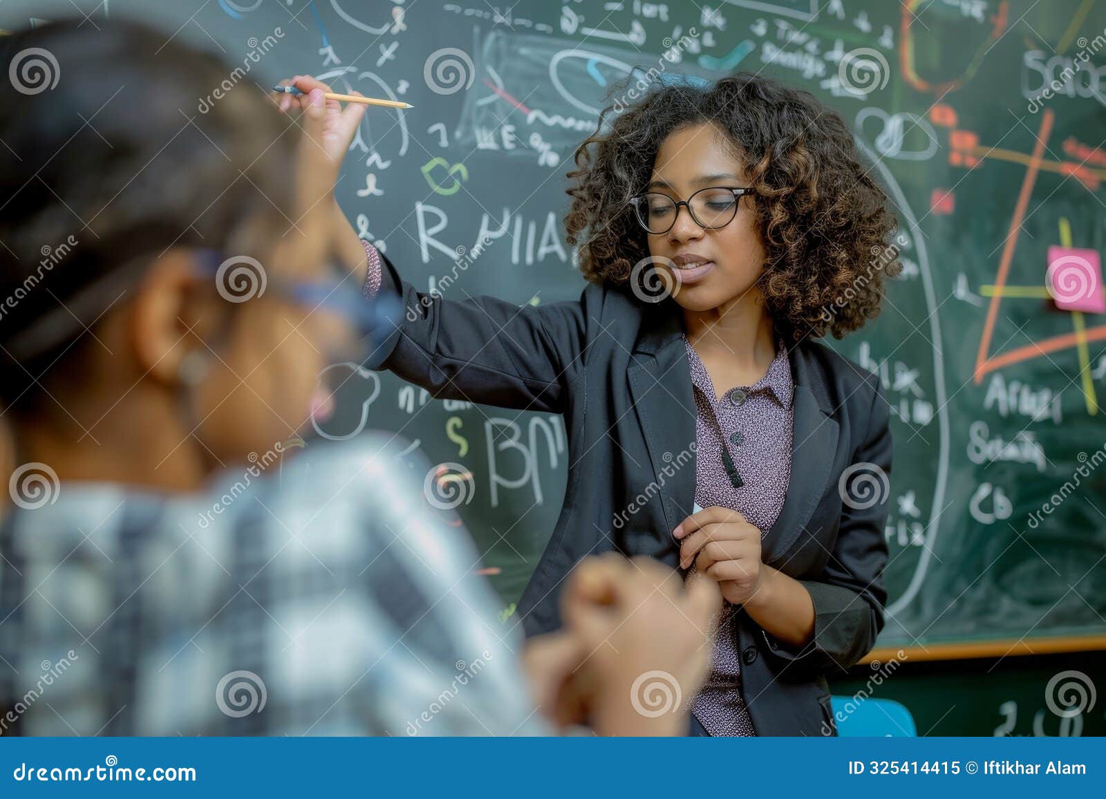 A Teacher Explains a Math Problem To a Student, Using a Chalkboard ...