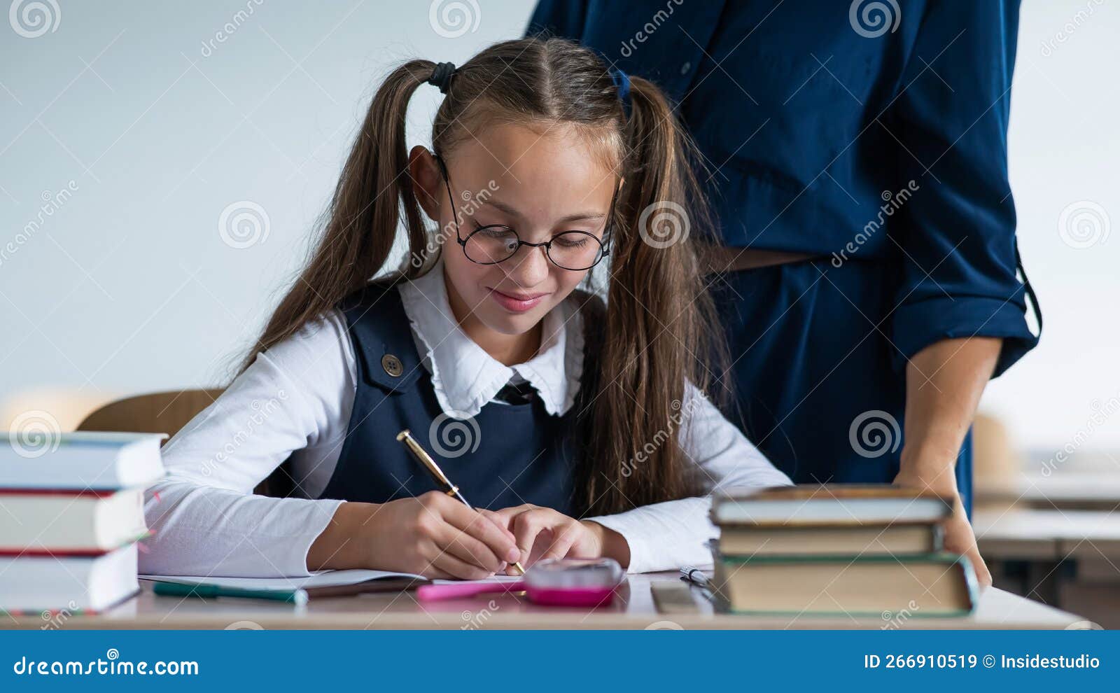 The Teacher Explains the Task To the Schoolgirl in the Classroom. Stock ...