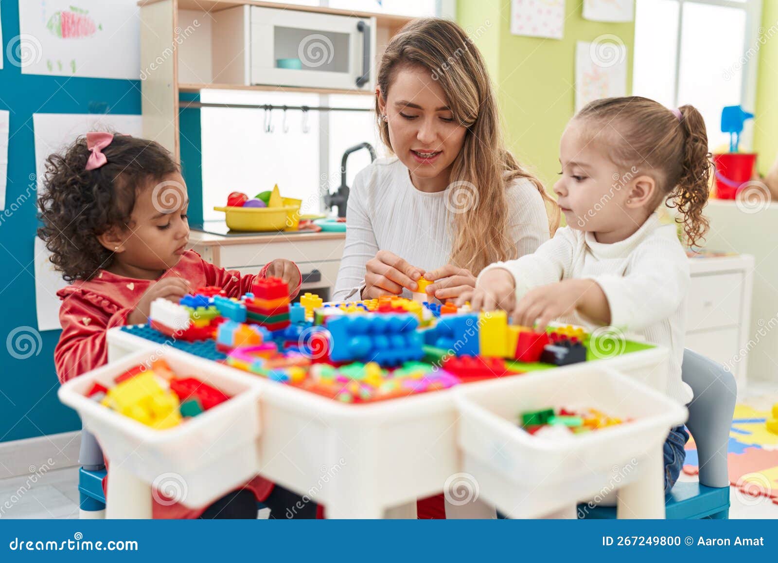 Teacher with Girls Playing with Construction Blocks Sitting on Table at ...