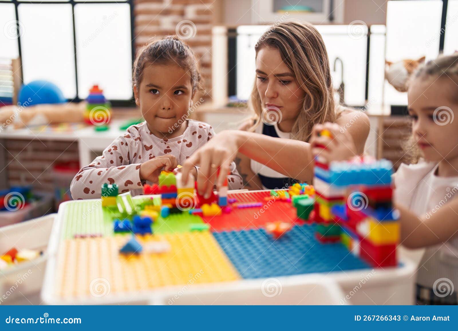 Teacher with Girls Playing with Construction Blocks Sitting on Table at ...
