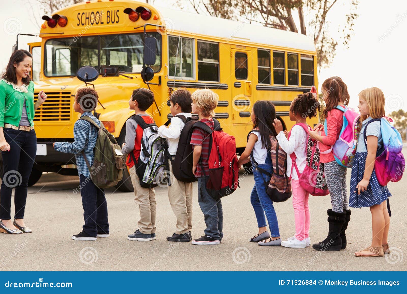 Teacher and a Group of Elementary School Kids at a Bus Stop Stock Photo ...