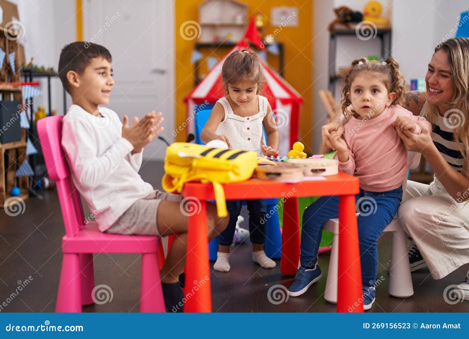 Teacher and Group of Kids Sitting on Table Applauding at Kindergarten ...