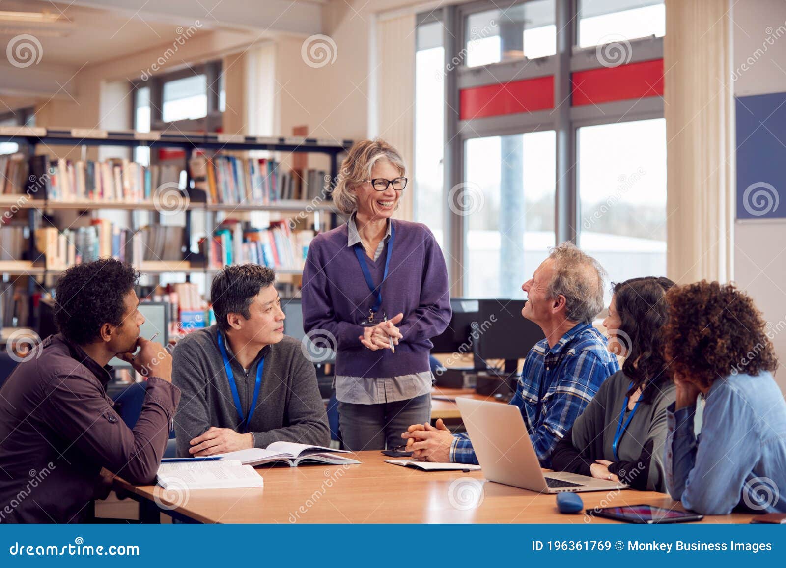 Teacher with Group of Mature Adult Students in Class Sit Around Table ...