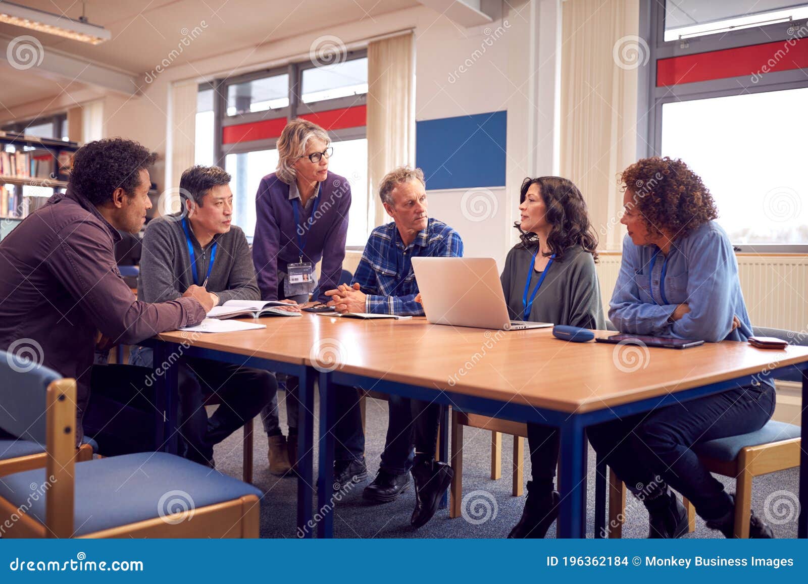 Teacher with Group of Mature Adult Students in Class Sit Around Table ...