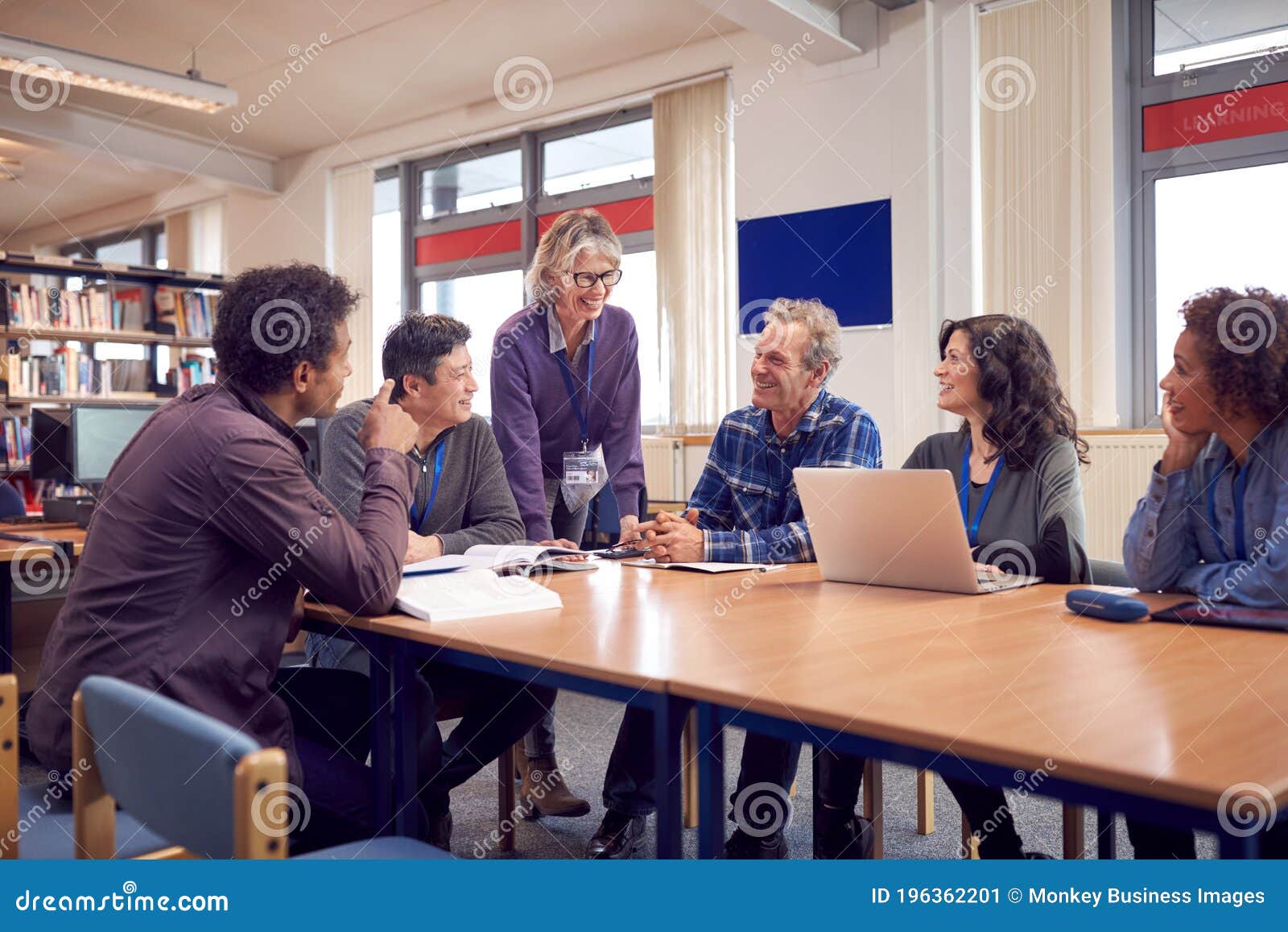 Teacher with Group of Mature Adult Students in Class Sit Around Table ...