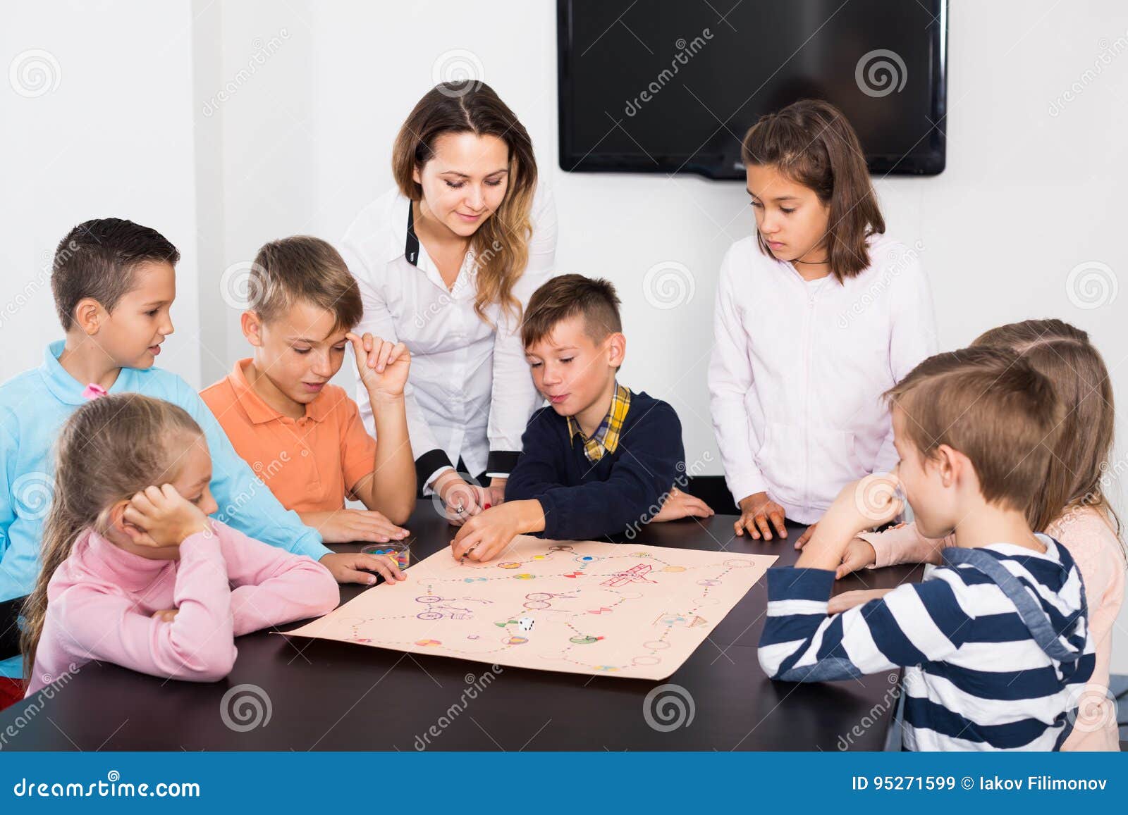 Teacher and Happy Kids Thinking at Table in Classroom Stock Image ...