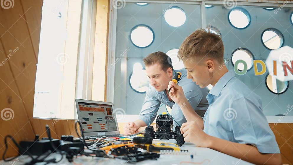 Teacher Help Student Fixing Car Model and Giving Advise at Class ...