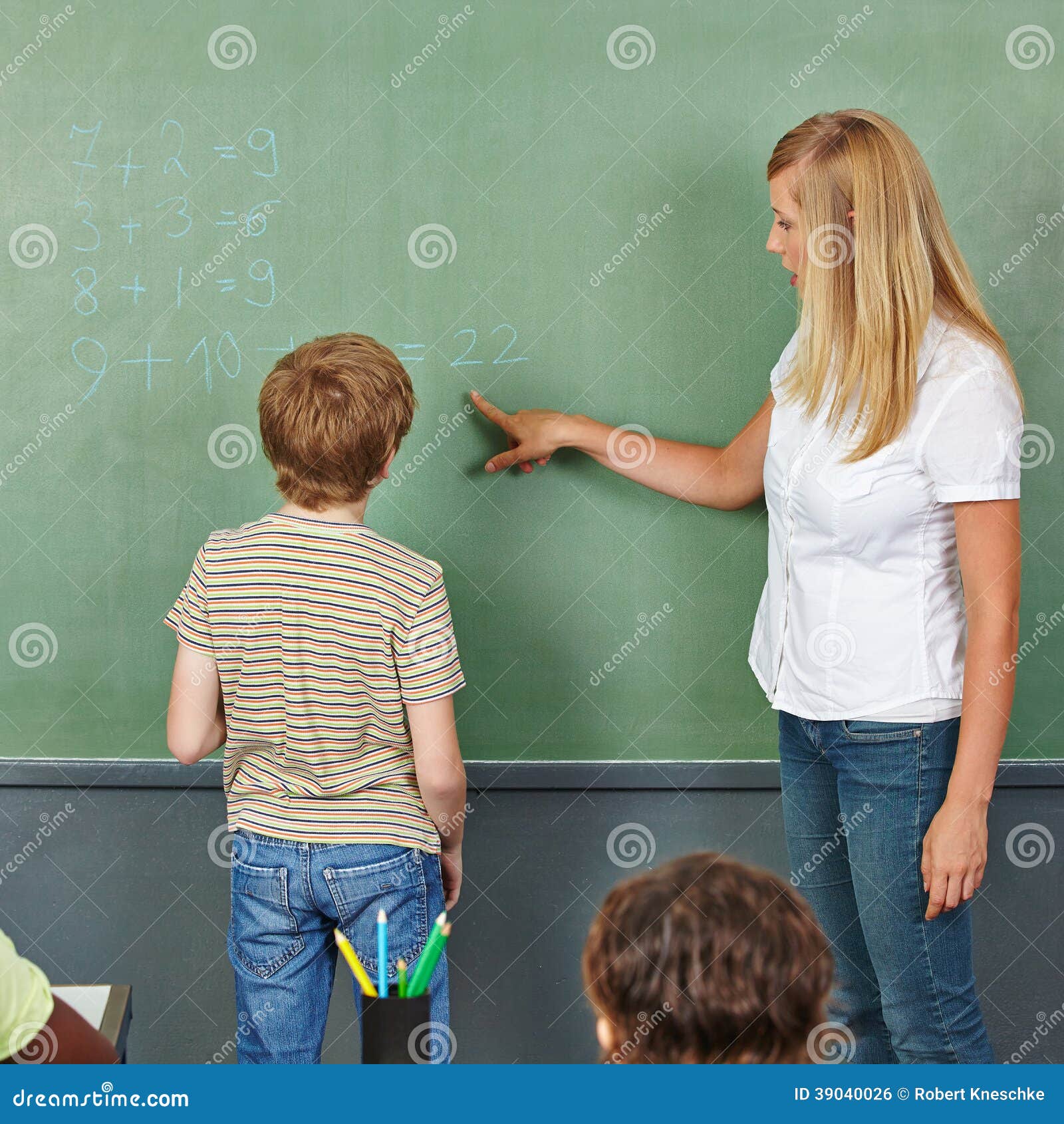 Teacher Helping Child at Chalkboard Stock Photo - Image of students ...