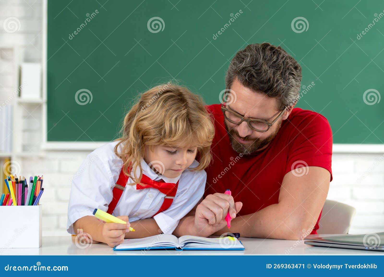 Teacher Helping Child Student Pupil from Elementary School in Classroom ...