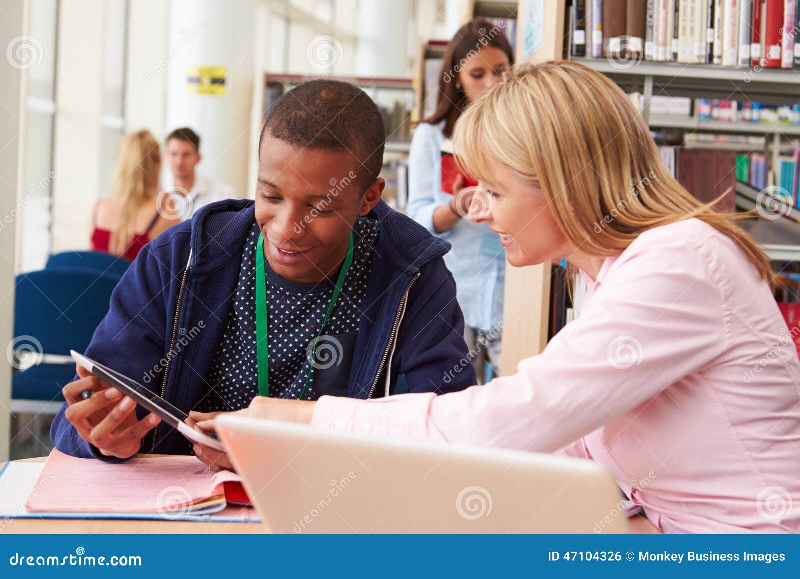 Teacher Helping College Student with Studies in Library Stock Photo ...
