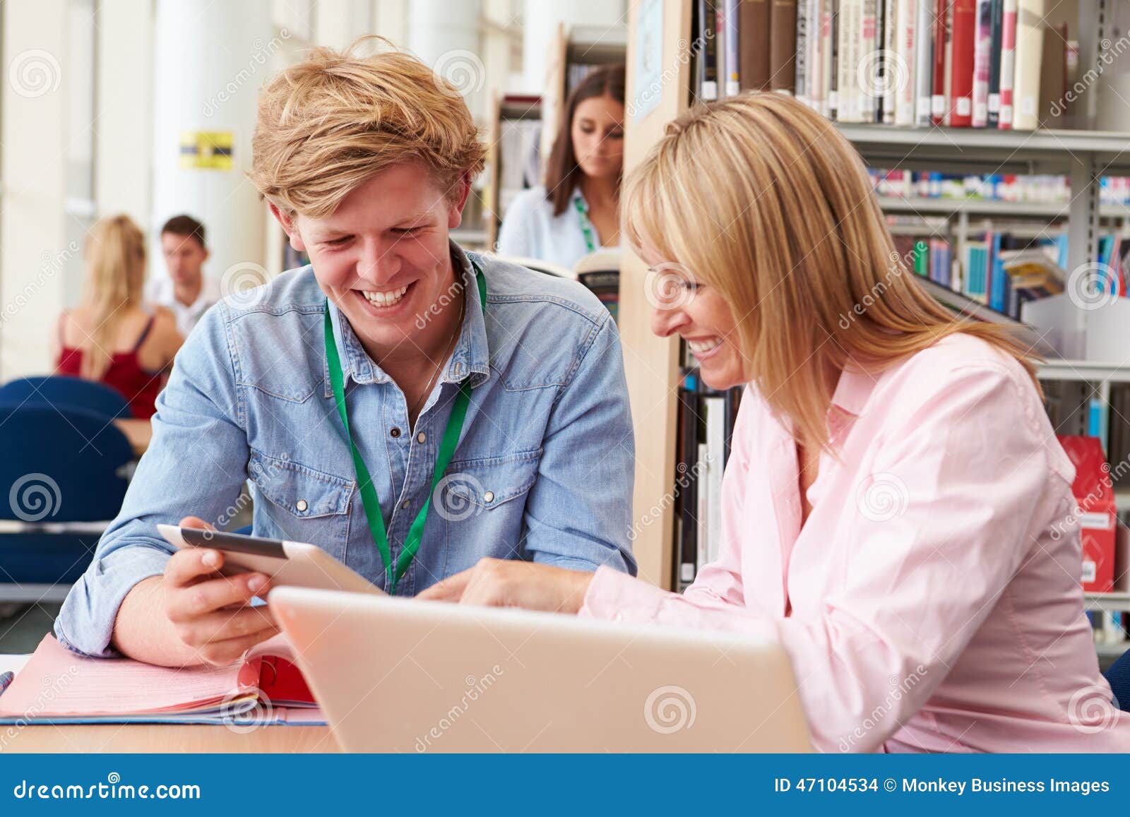Teacher Helping College Student with Studies in Library Stock Photo ...
