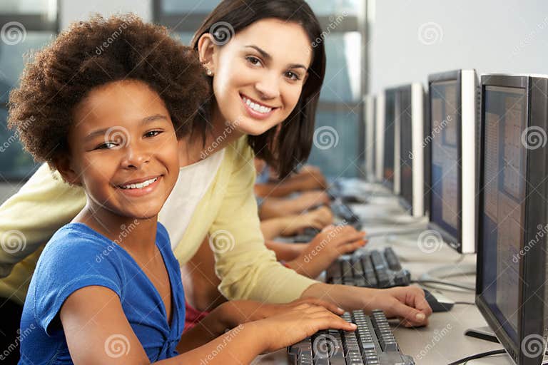 Teacher Helping Elelmentary Students Working at Computers Stock Image ...