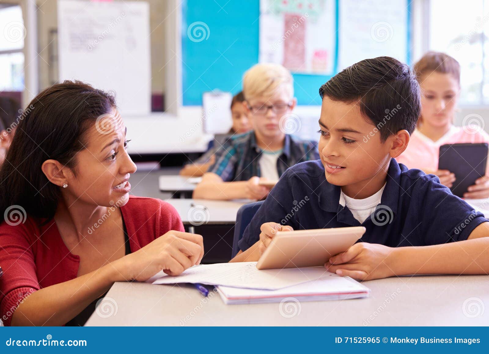 Teacher Helping Elementary School Boy Using Tablet Computer Stock Image ...