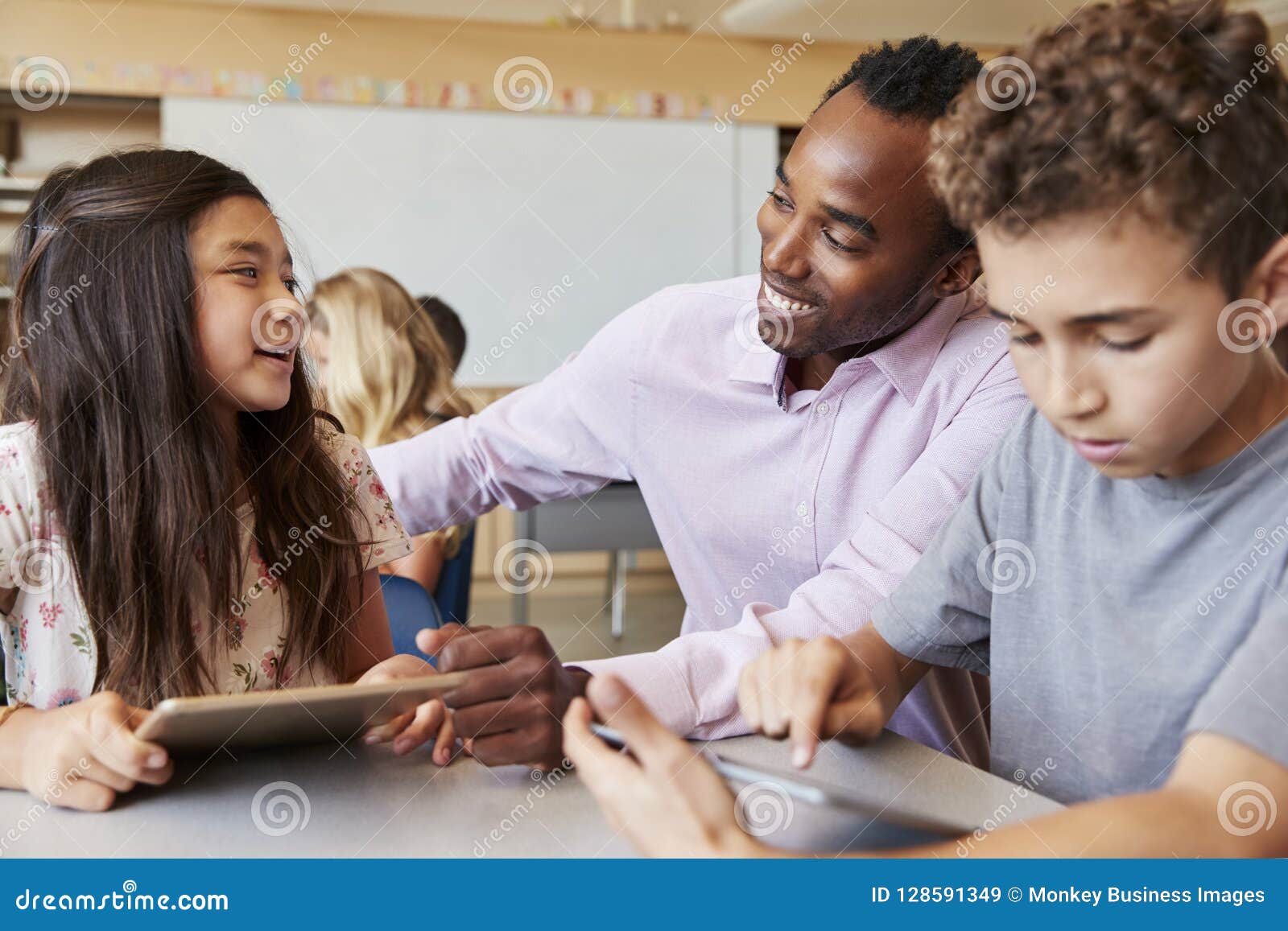 Teacher Helping Elementary School Kids Using Tablet Computer Stock ... Teacher Helping Elementary School Kids Using Tablet Computer Stock ...
