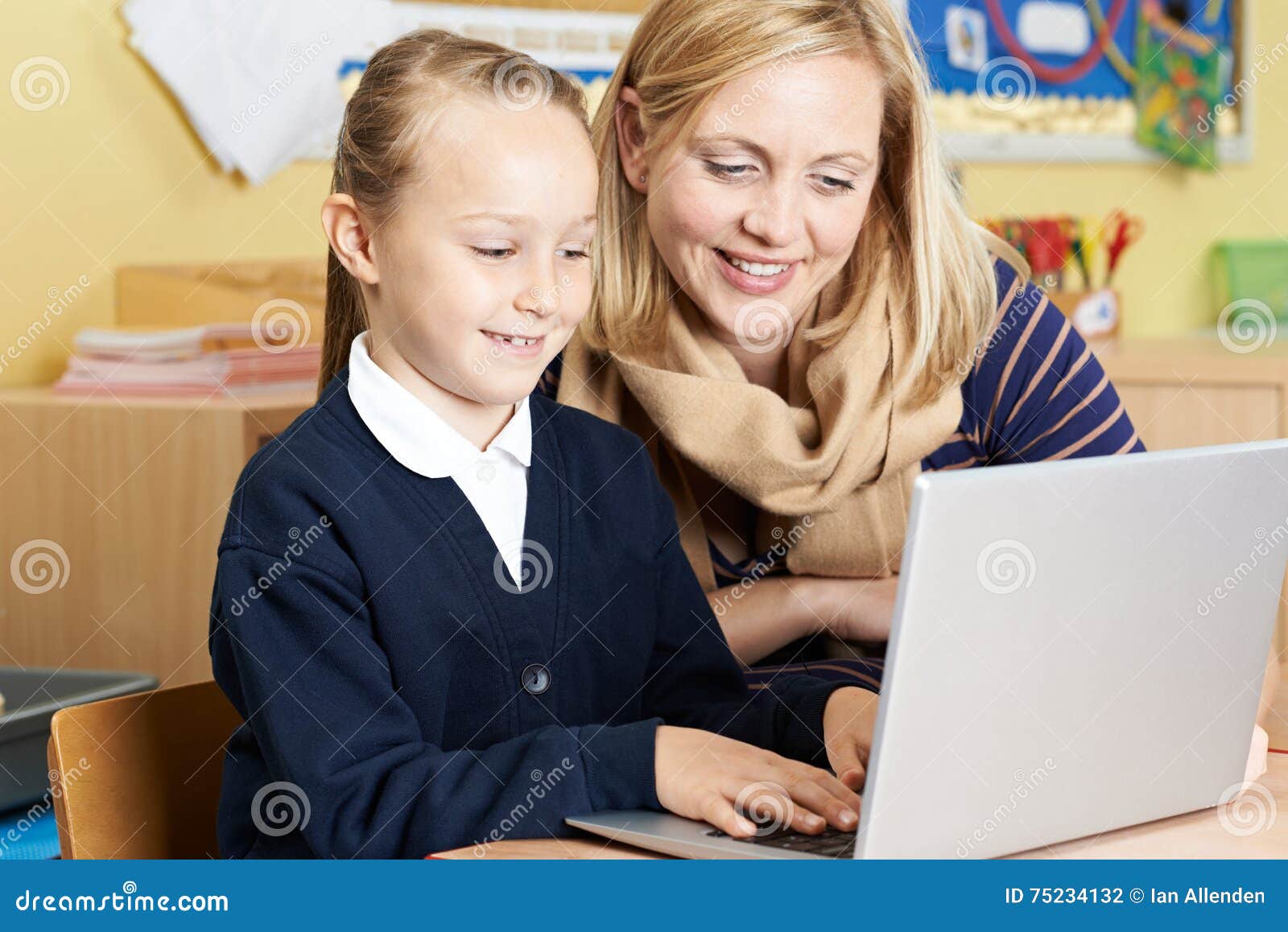 Teacher Helping Female Elementary School Pupil in Computer Class Stock ...