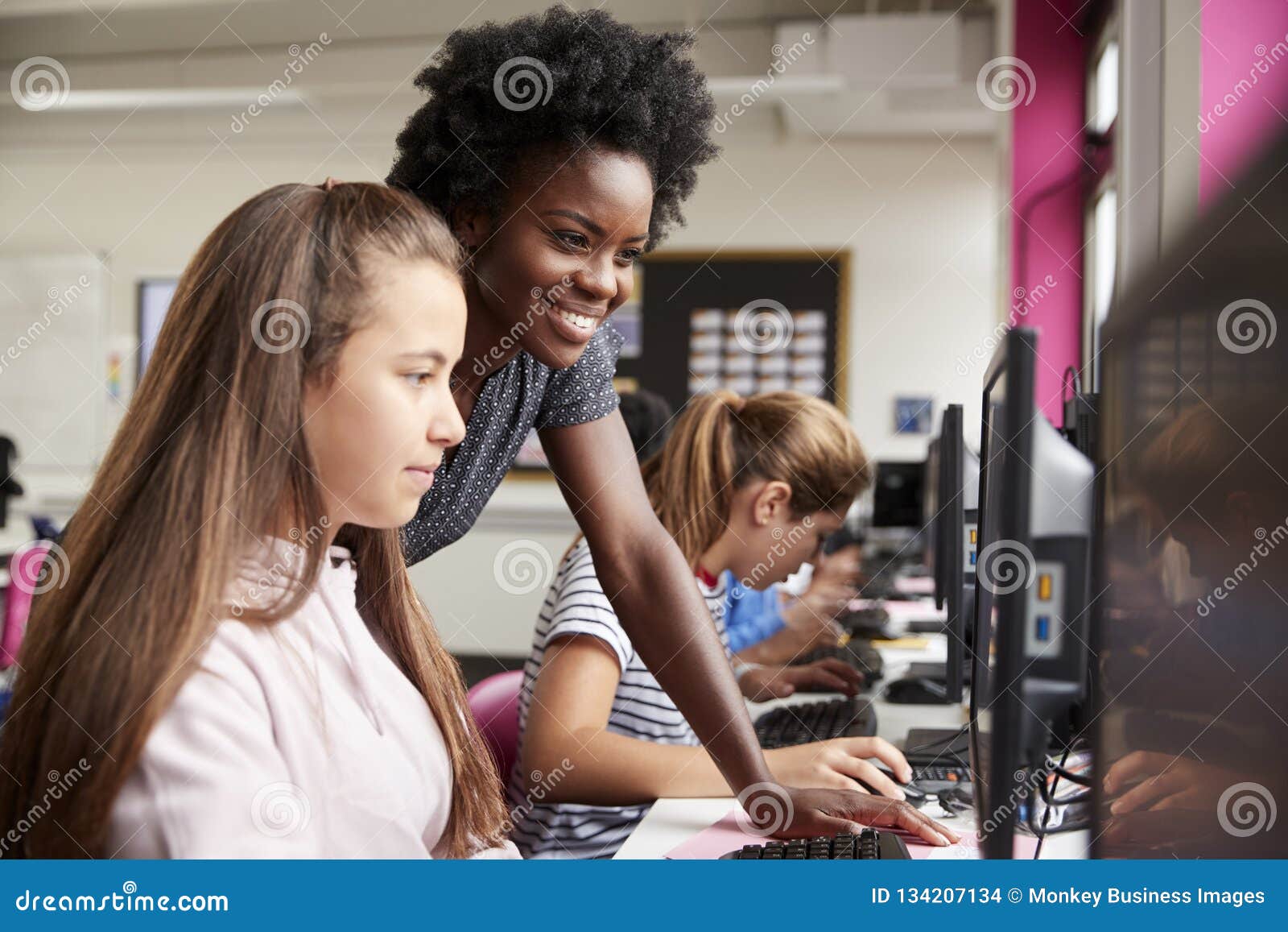 Teacher Helping Female Pupil Line of High School Students Working at ...