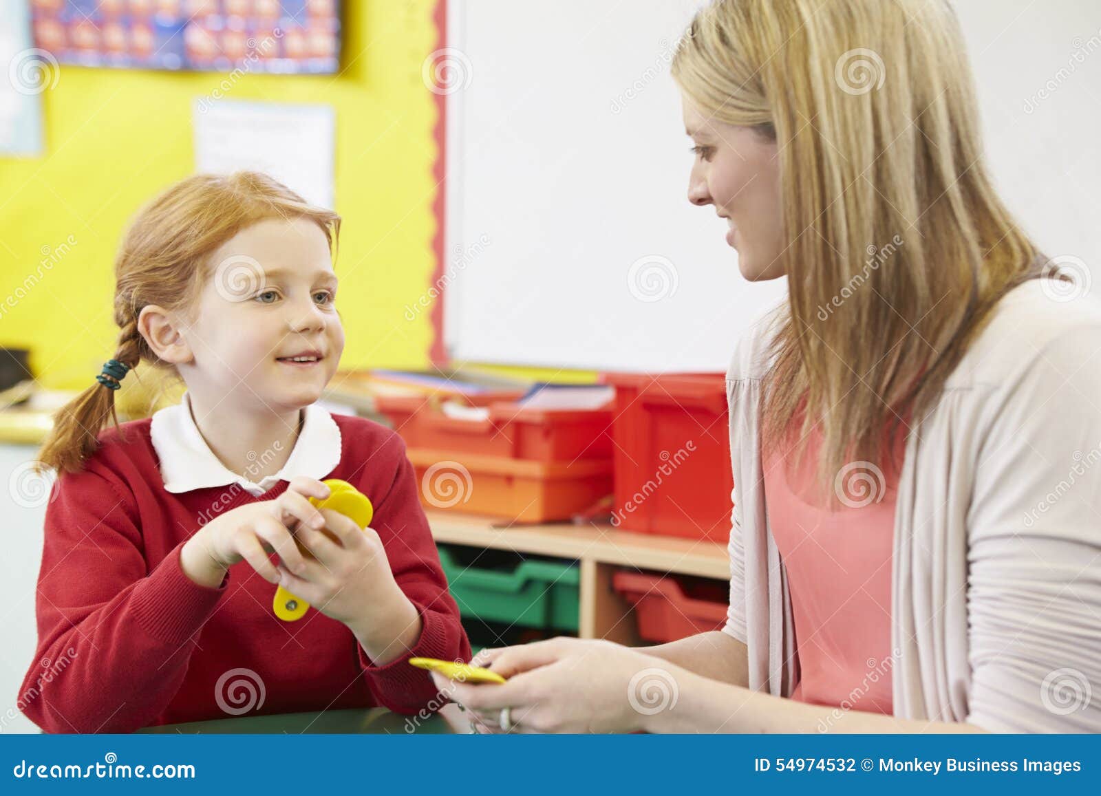 Teacher Helping Female Pupil with Maths at Desk Stock Photo - Image of ...