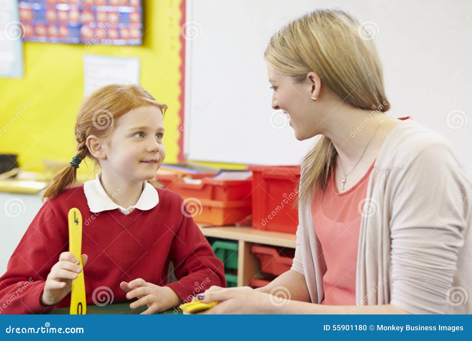 Teacher Helping Female Pupil with Maths at Desk Stock Photo - Image of ...