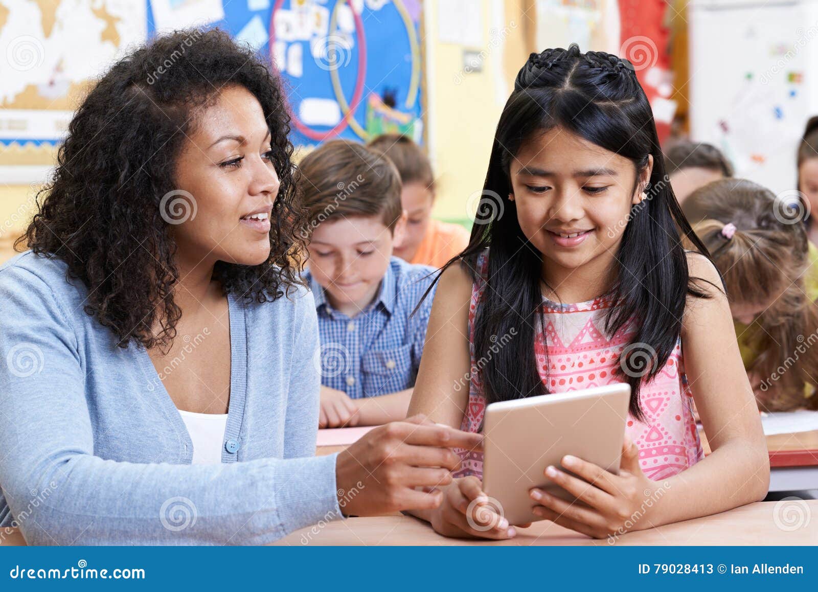 Teacher Helping Group of Elementary School Children in Computer Stock ...