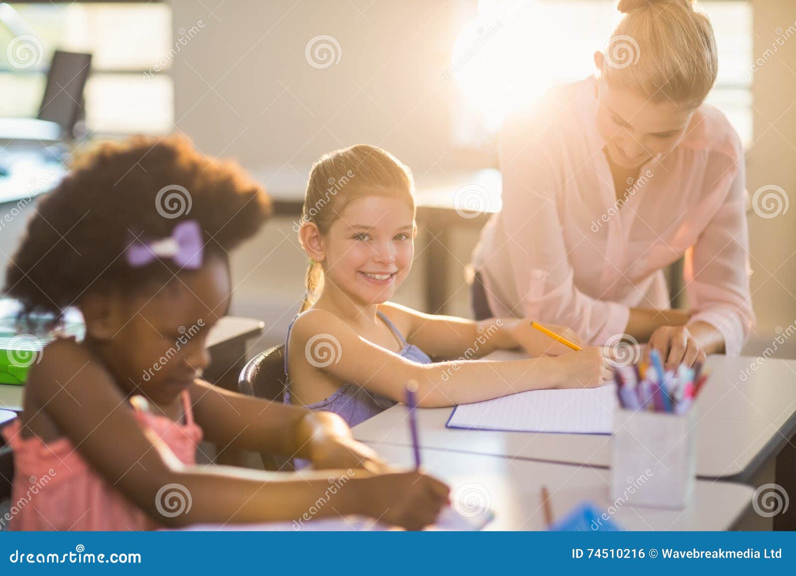 Teacher Helping Kids with Their Homework in Classroom Stock Photo ...