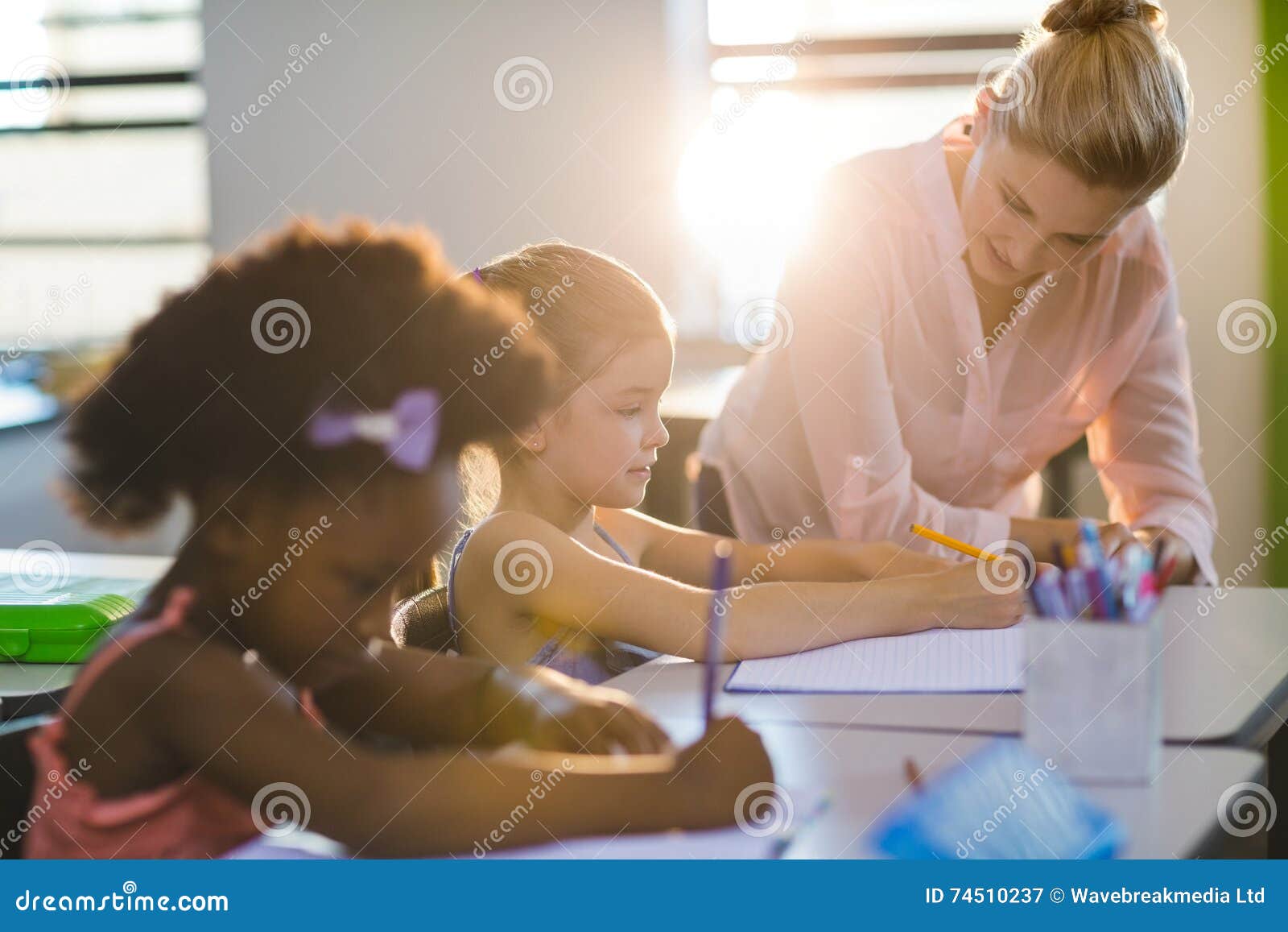 Teacher Helping Kids with Their Homework in Classroom Stock Image ...