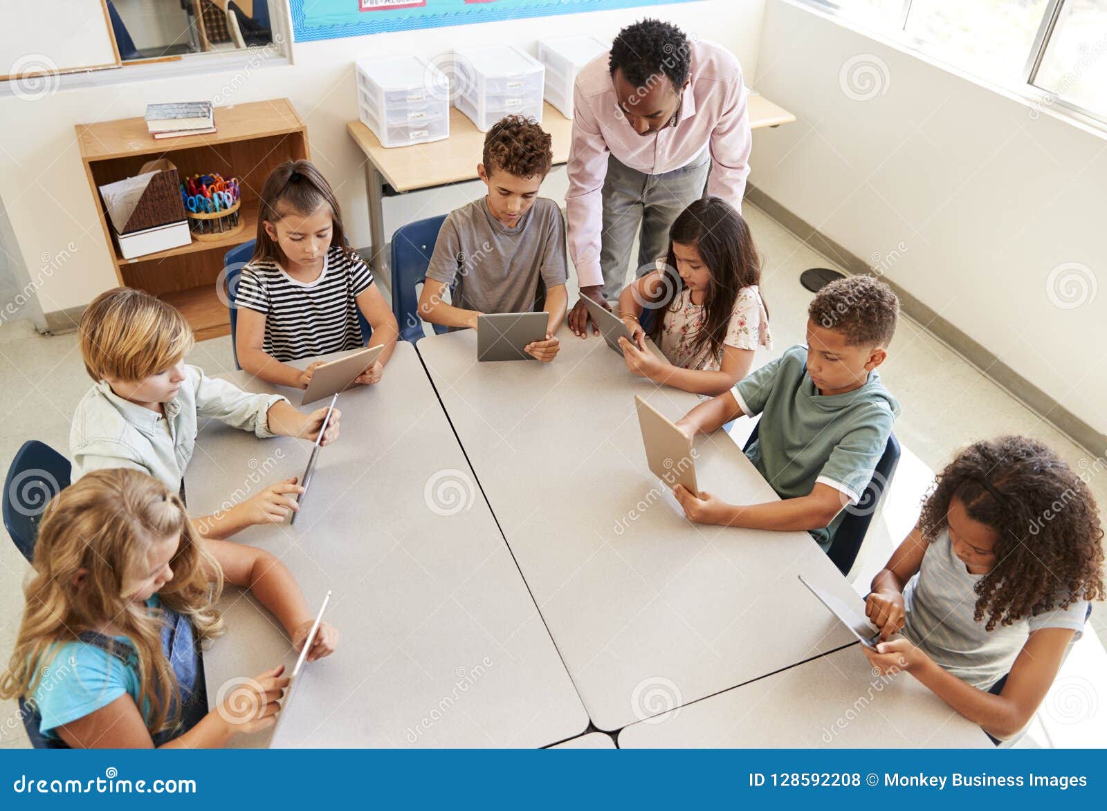 Teacher Helping Kids Using Tablets in Lesson, Elevated View Stock Photo ...