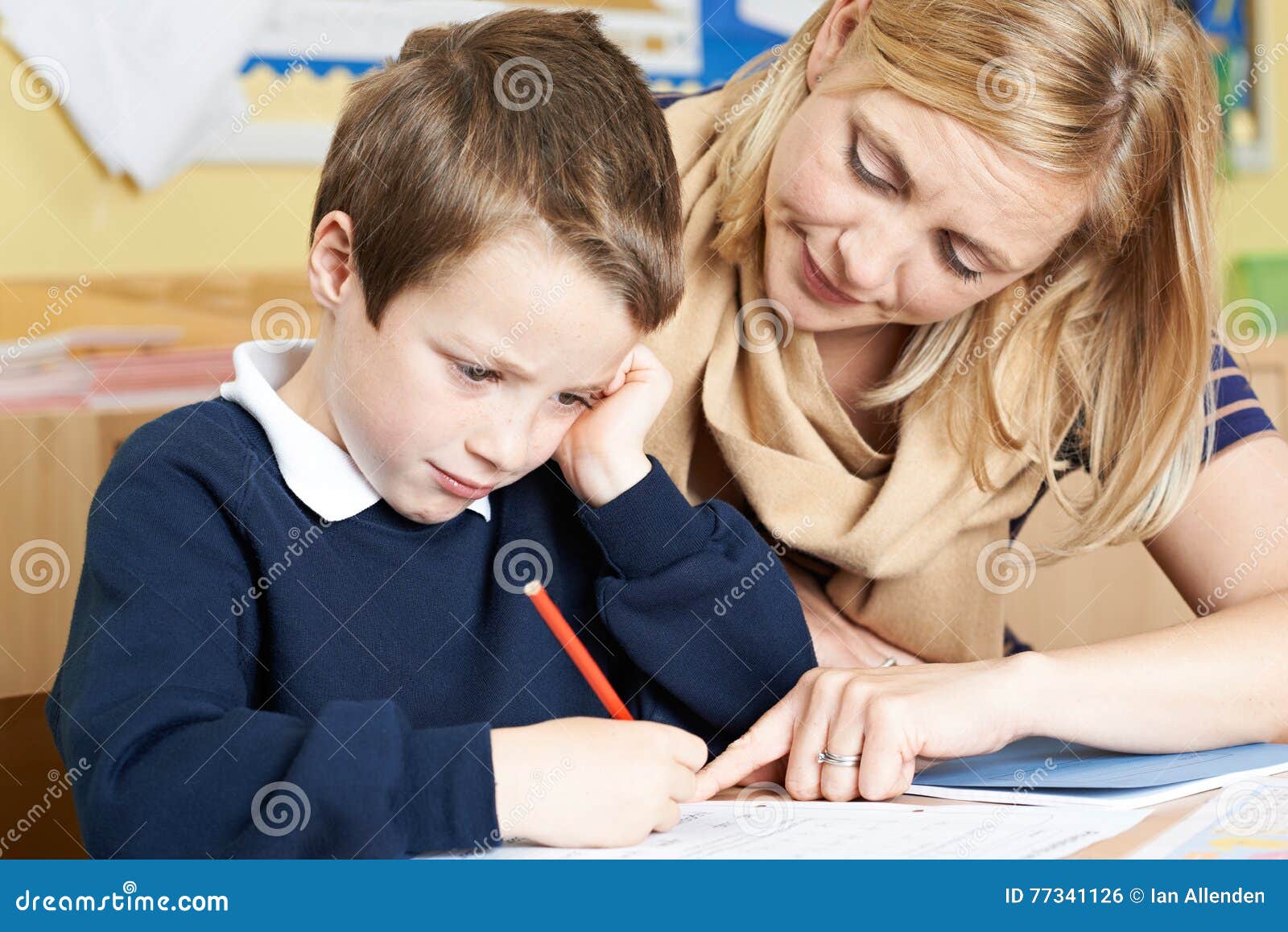 Teacher Helping Male Elementary School Pupil with Problem Stock Photo ...