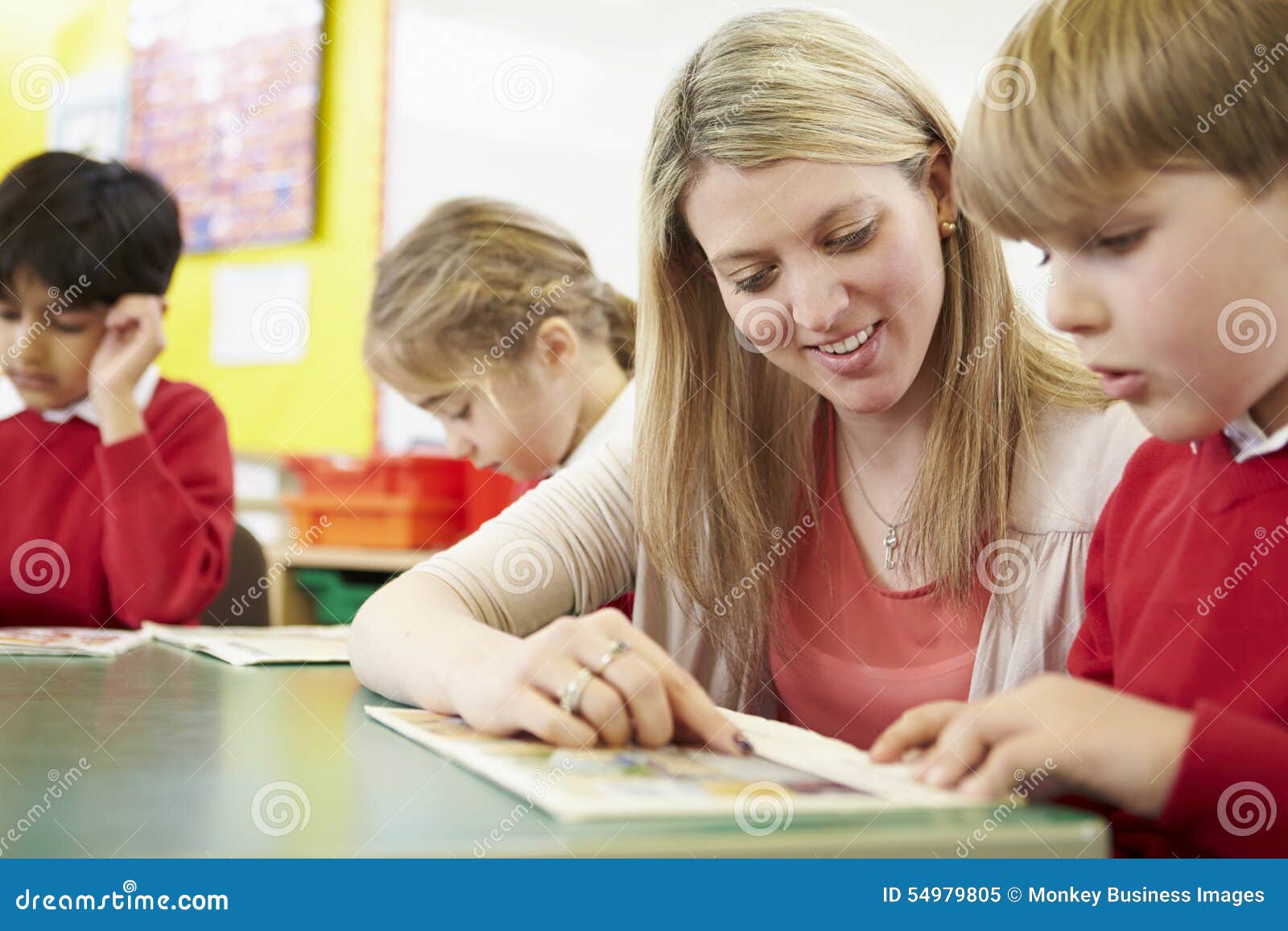 Teacher Helping Male Pupil with Reading at Desk Stock Image - Image of ...