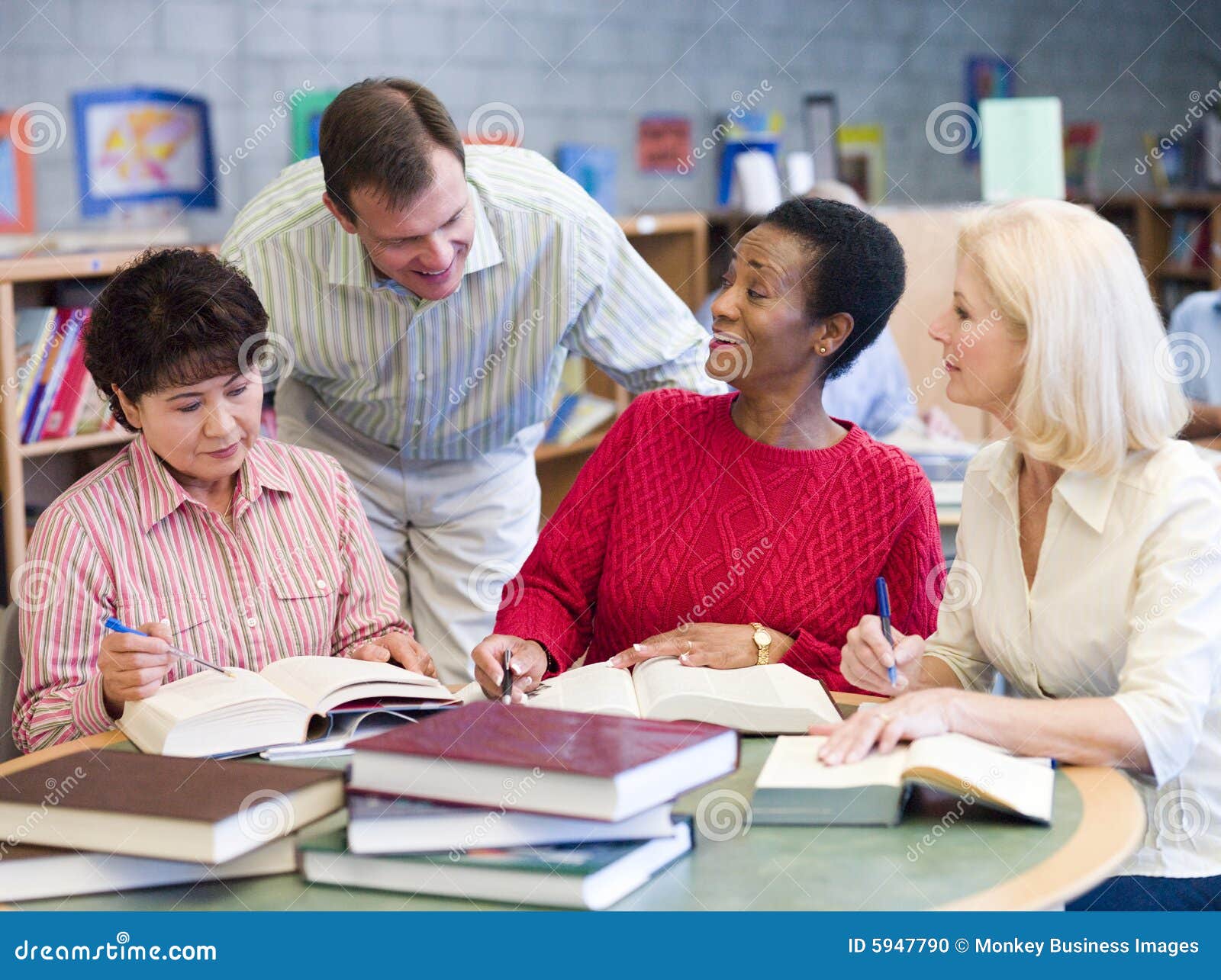 Teacher Helping Mature Students in Library Stock Photo - Image of ...
