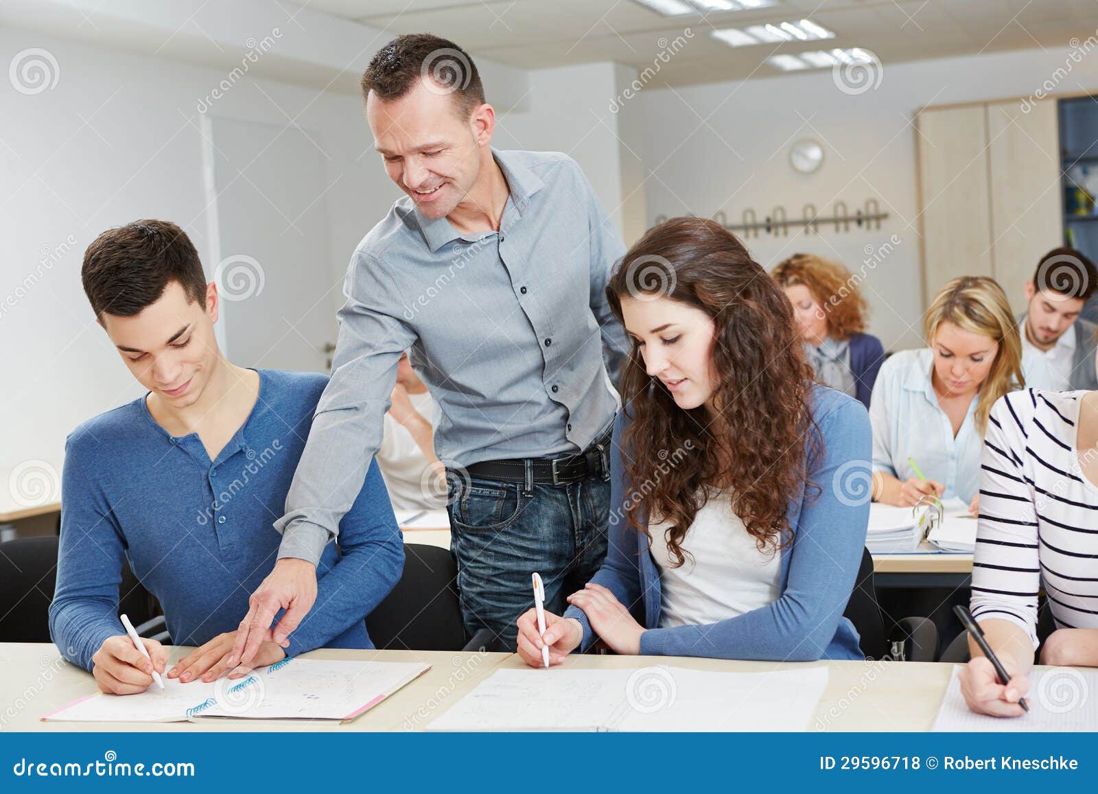 Teacher Helping Pupil in School Stock Photo - Image of pupil, learn ...
