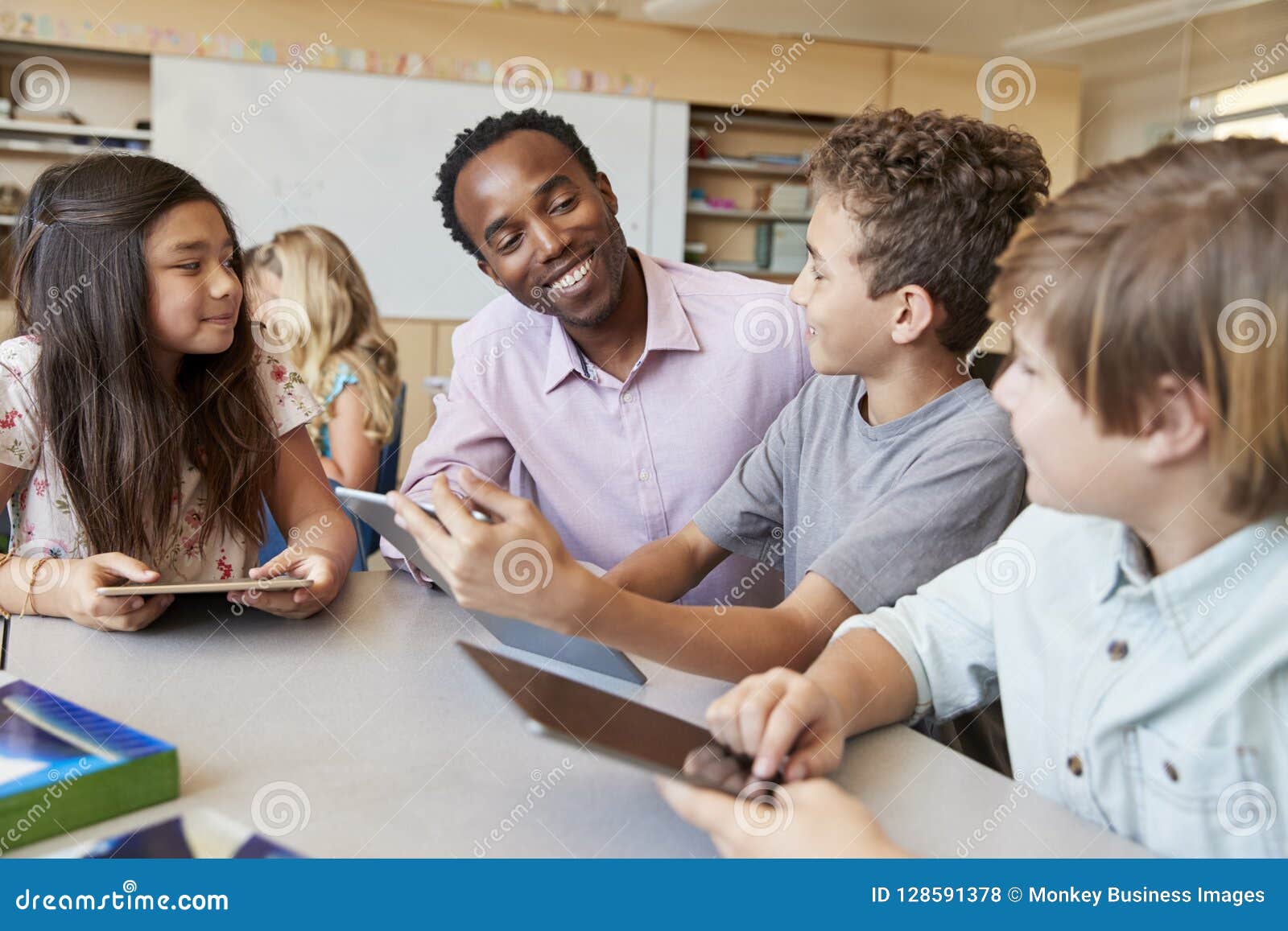 Teacher Helping School Kids Using Tablet Computers in Class Stock Photo ... Teacher Helping School Kids Using Tablet Computers in Class Stock Photo ...