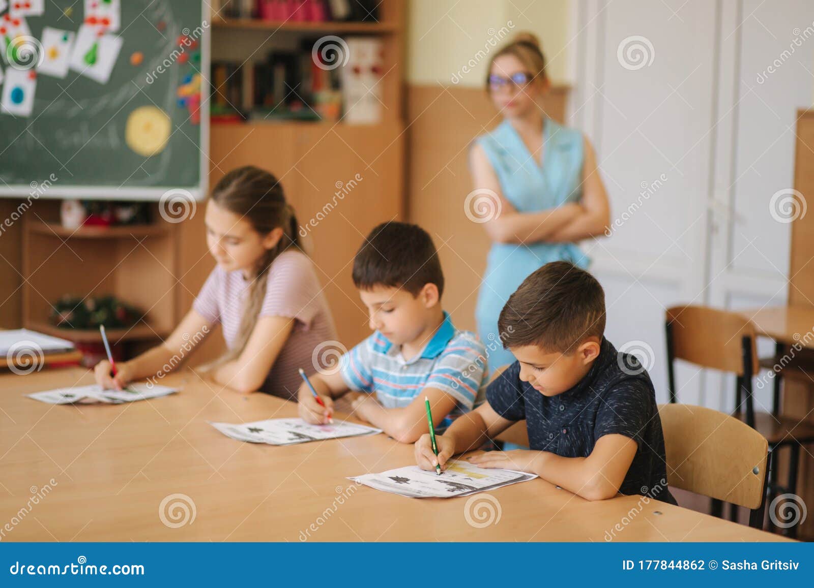 Teacher Helping School Kids Writing Test in Classroom. Education ...
