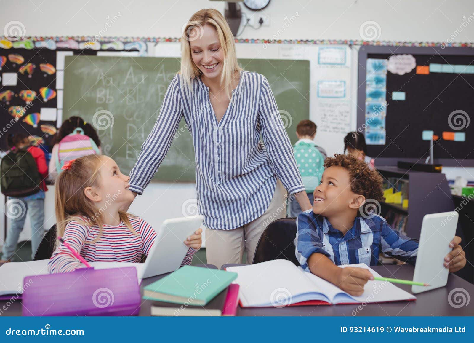 Teacher Helping Schoolkids with Their Homework in Classroom Stock Image ...