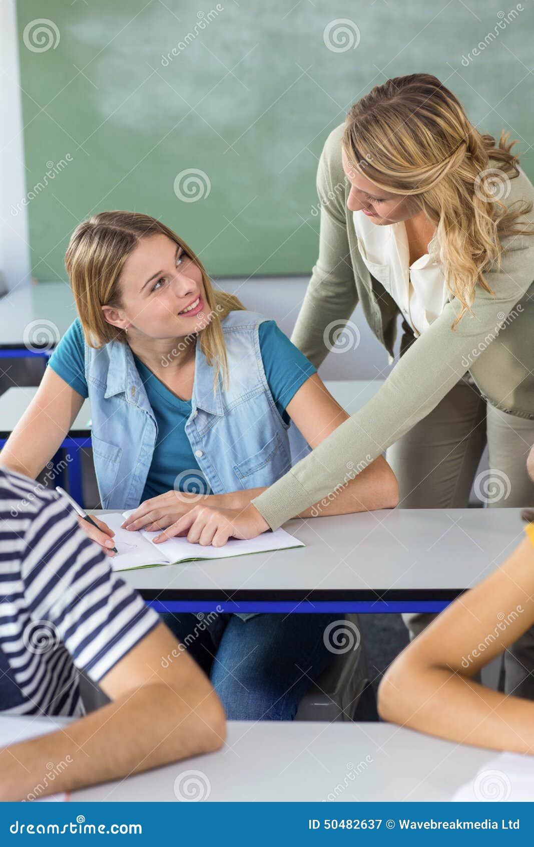 Teacher Helping Student in Class Stock Image - Image of showing ...