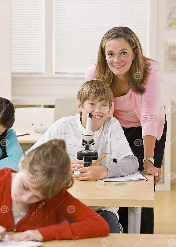 Teacher Helping Student with Microscope Stock Image - Image of curious ...