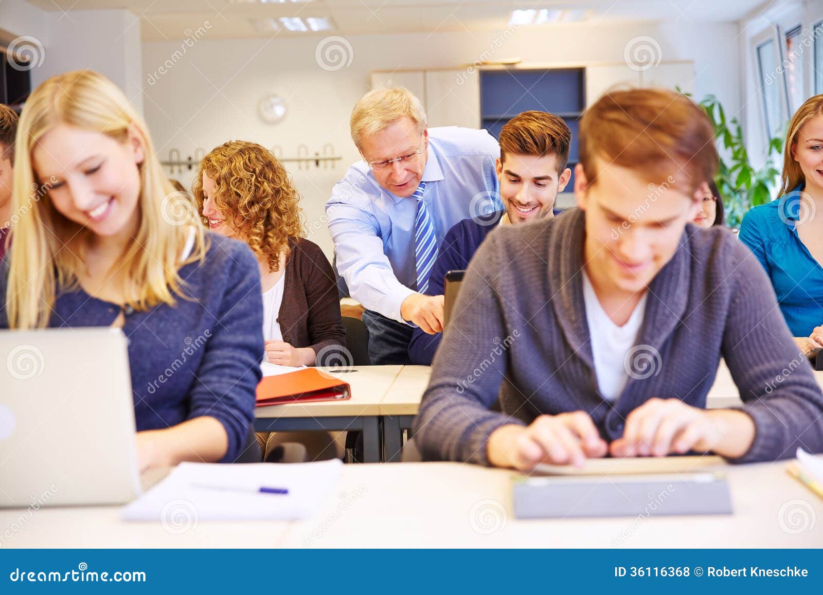Teacher Helping Student in School Stock Photo - Image of college ...