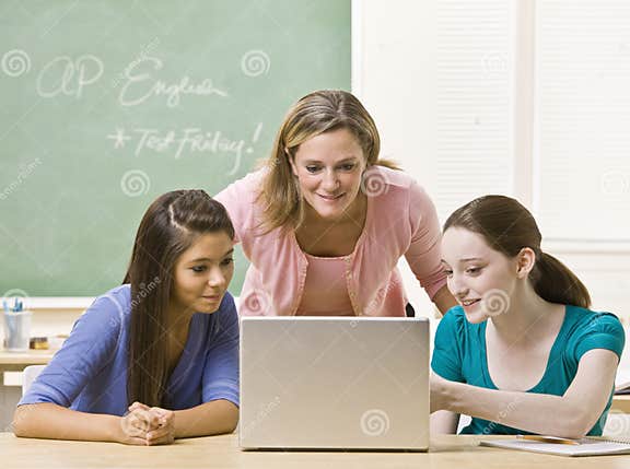Teacher Helping Students on Laptop Stock Image - Image of people ...