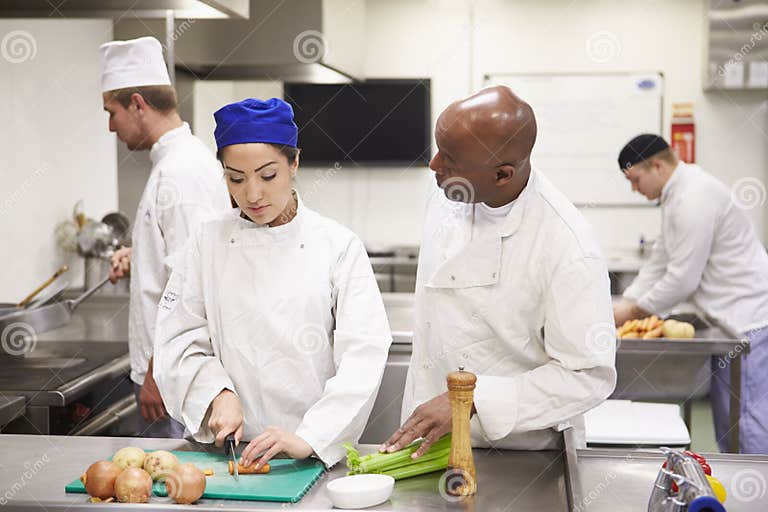Teacher Helping Students Training To Work in Catering Stock Photo ...
