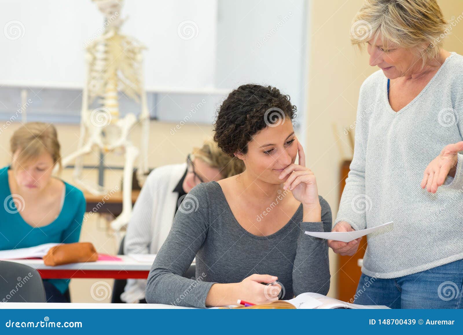 Teacher Holding Paper and Questioning Student in Anatomy Class Stock ...