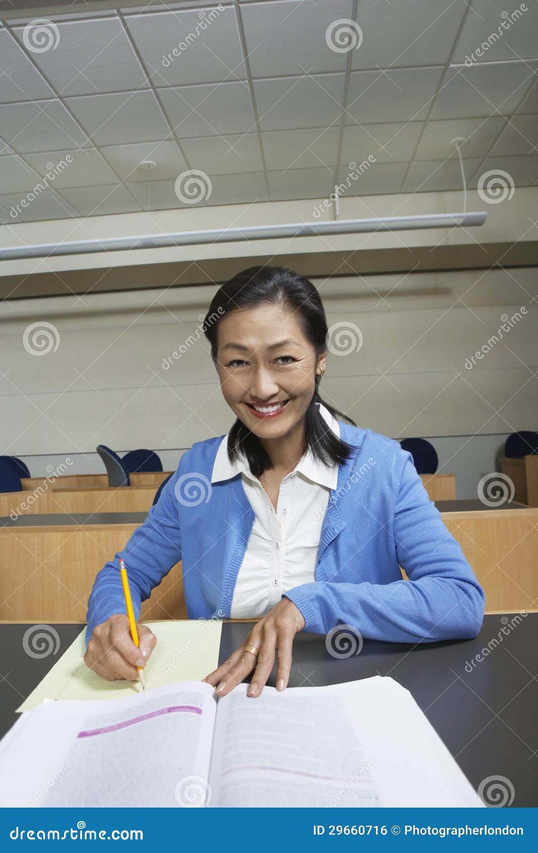 Teacher Jotting Down Notes in Classroom Stock Photo - Image of ...